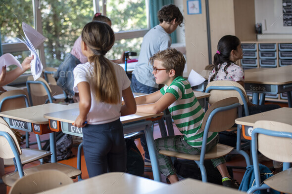 Group of young students in class having lunch and messing around ...