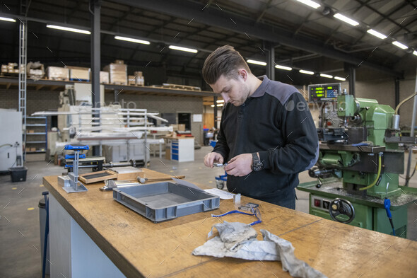 Young mechanical engineer working on steel machinery in a factory Stock ...
