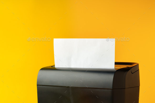 Office paper shredder on yellow studio background Stock Photo by ...