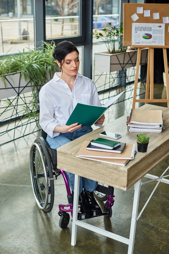 dedicated businesswoman with mobility disability in wheelchair looking ...