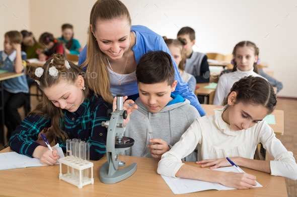 Students using science beakers and a microscope at the elementary ...