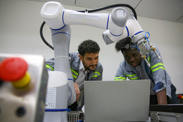 Robotic Arm engineer check on equipment in its with software of ...