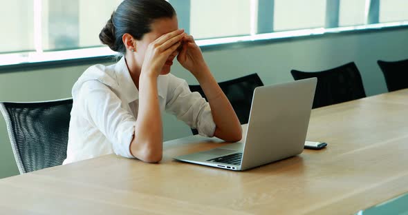 Executive crying while working on laptop in conference room, Stock Footage