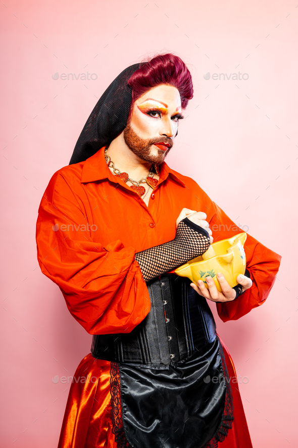 Drag Queen Dressed in Vibrant Attire Posing With Mortar Against Pink ...