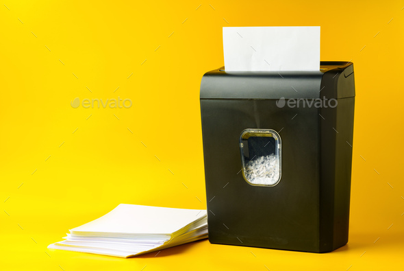 Office paper shredder on yellow studio background Stock Photo by ...