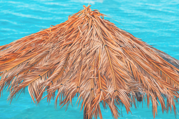 Dry palm leaf beach parasol for sun protection at seaside during summer ...