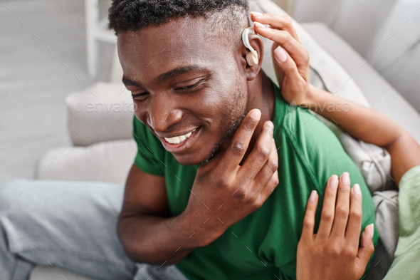 deaf african american man smiling as his girlfriend assists with ...