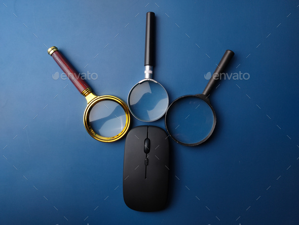 Top view magnifying glass and wireless mouse on a blue background Stock ...