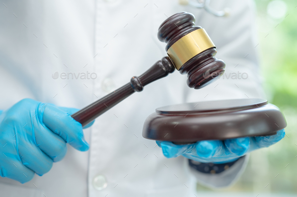 Doctor holding judge gavel, forensic medicine, medical law and crime ...