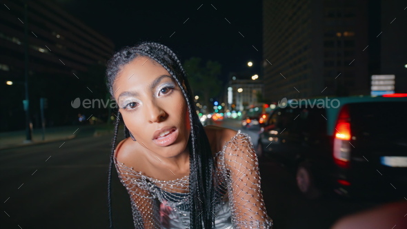 Dreadlocks girl staring lens at night lights traffic road portrait ...