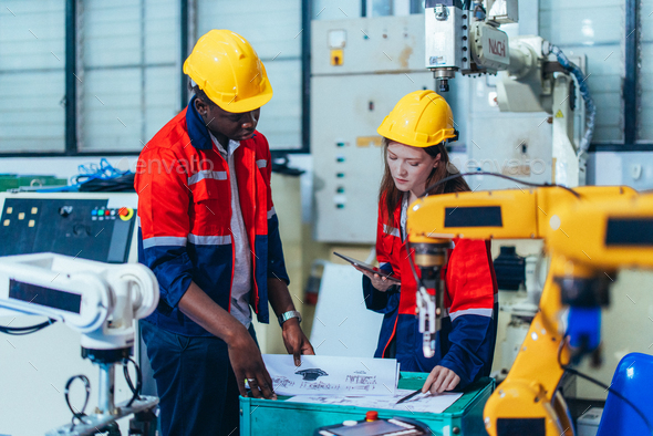 Trainees programing robotic arm in practical lesson at robotics academy ...
