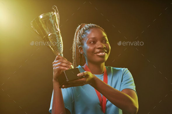 Female Athlete Holding Trophy Stock Photo by seventyfourimages | PhotoDune