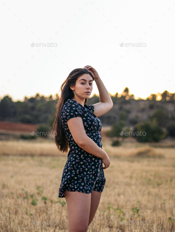 Portrait of a pretty young woman with long hair in the countryside ...