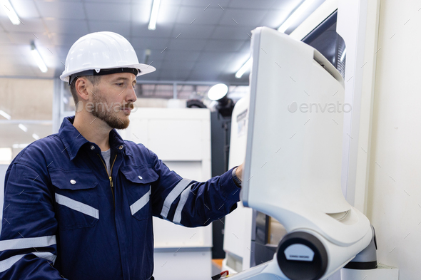 Man engineer using computer controlling cnc machine at workshop. Stock ...