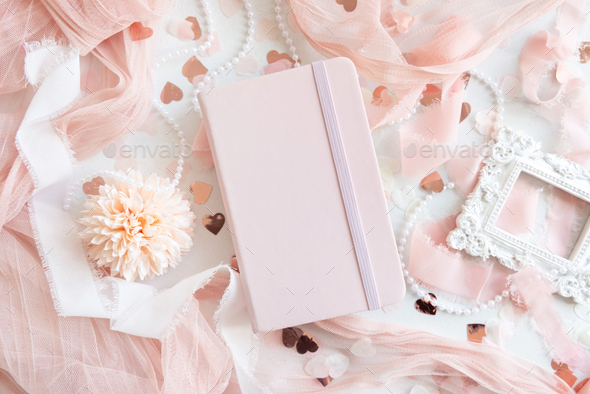 Pink hardcover notebook near hearts and romantic pink decor top view ...