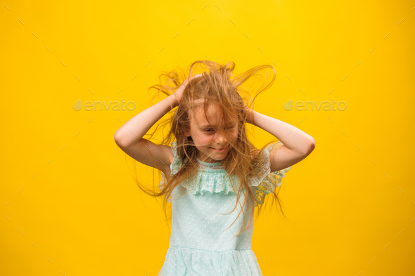 disheveled, kid girl scratch hair on the yellow background Stock Photo ...