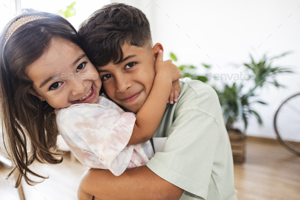 Affectionate Siblings Embracing with Joy Stock Photo by josecarloscerdeno