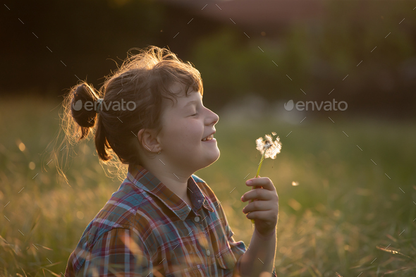 Cute little girl having fun in a dandelion field Stock Photo by erika8213