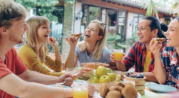Happy young people eating healthy food at farm house picnic Stock Photo ...
