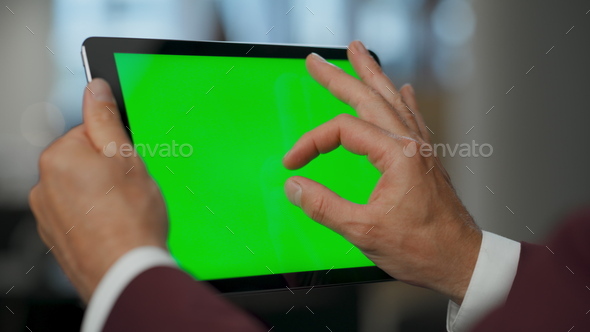 Manager hand zooming green tablet screen closeup. Man touching ...