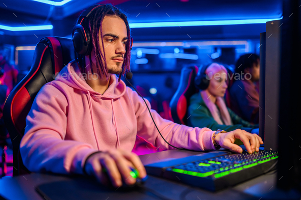Young man with dreadlocks and mustaches playing video games in an ...