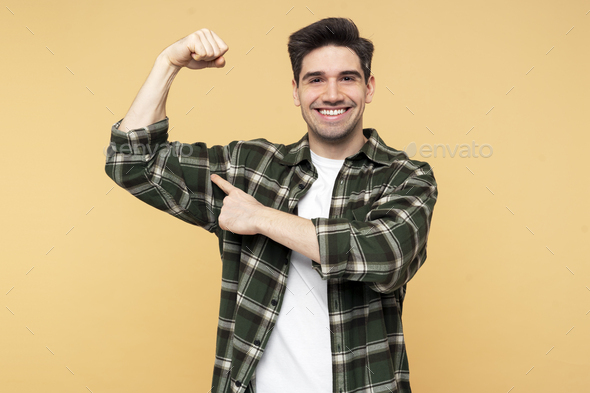 Man, showing a muscle gesture, pointing at his biceps with his ...