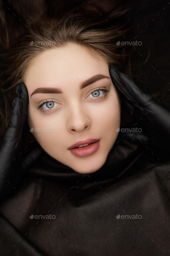 Completed work permanent eyebrow makeup girl touches with fingers ...