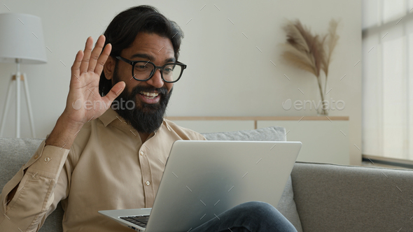 Smiling Arabian Indian muslim man talking virtual on laptop greet ...