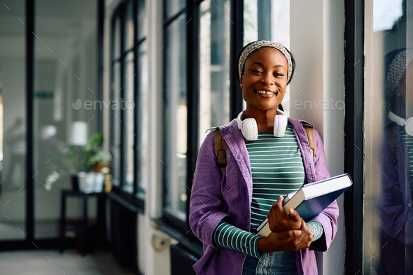 Portrait of happy black female student at the university looking at ...