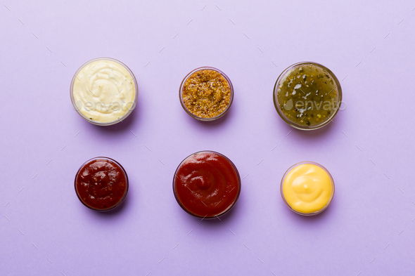 Different types of sauces in bowls on a colored Board . Top view ...
