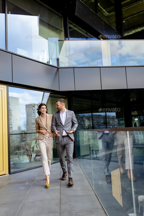 Cheerful Colleagues Exiting a Modern Office Building on a Bright ...