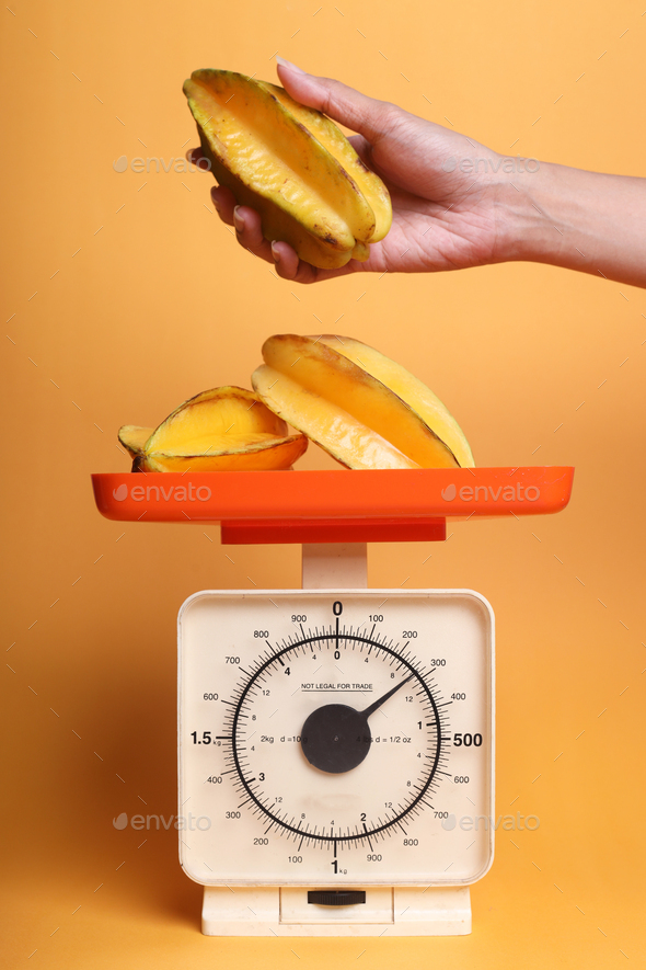 Female Hand Measure Star Fruit on Scale Stock Photo by Queenmoonlite35