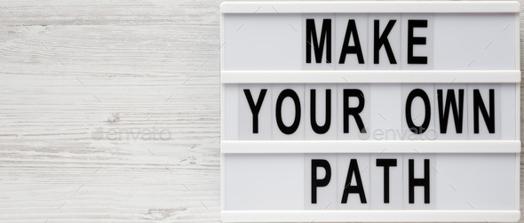 'Make your own path' words on a lightbox on a white wooden background ...