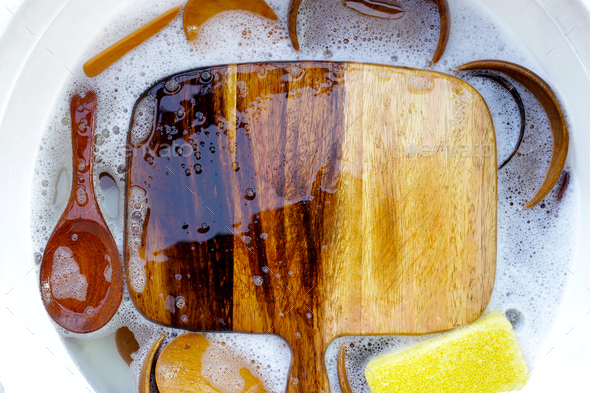 Wooden kitchenware in water and bubbles of dishwashing liquid Stock ...