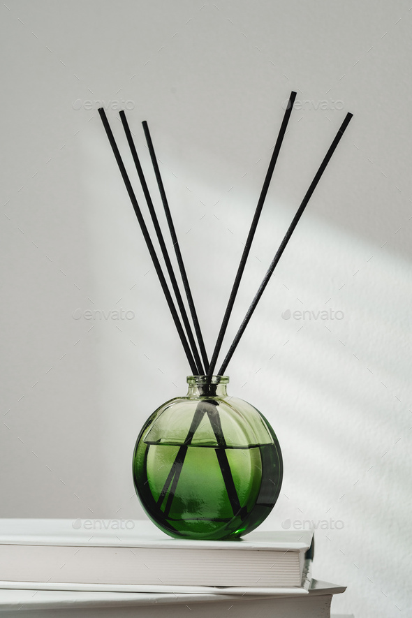 Aromatic Reed Diffuser on White Books With Shadows Playing on the Wall ...