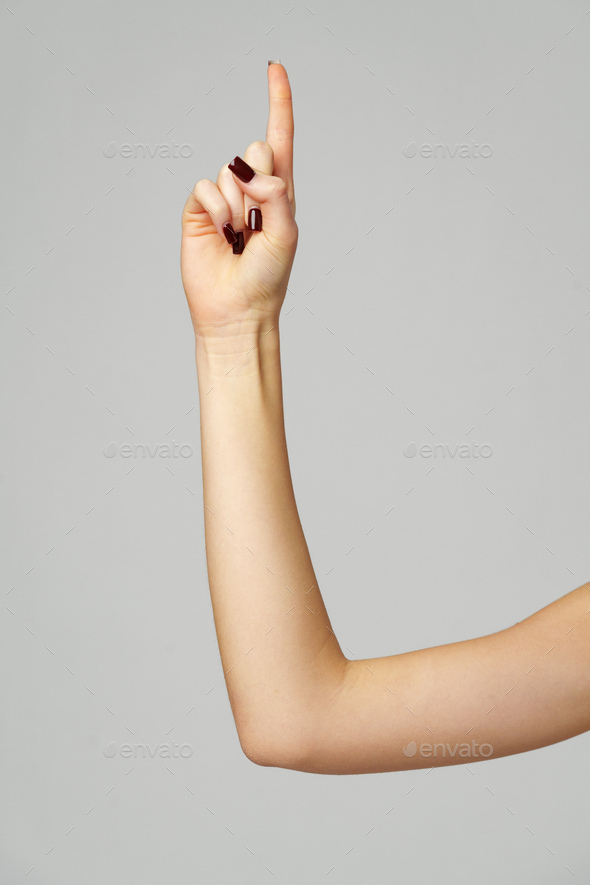 Female hand showing one finger up on gray background Stock Photo by ...