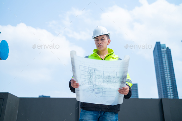 Construction Engineer Evaluating Blueprints on Rooftop Stock Photo by ...