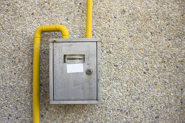 Close-up of metal steel gas meter box with connecting yellow pipes ...