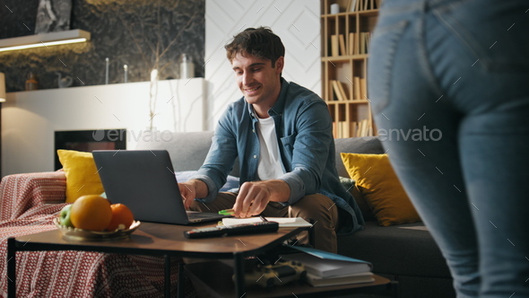 Relaxed family evening home in cozy living room. Woman bringing coffee ...