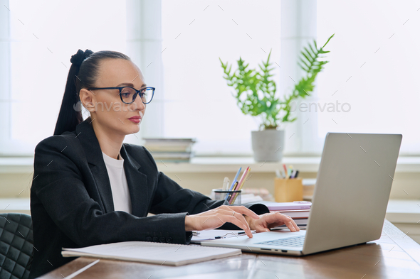 Business woman working in home office at desk with laptop computer ...