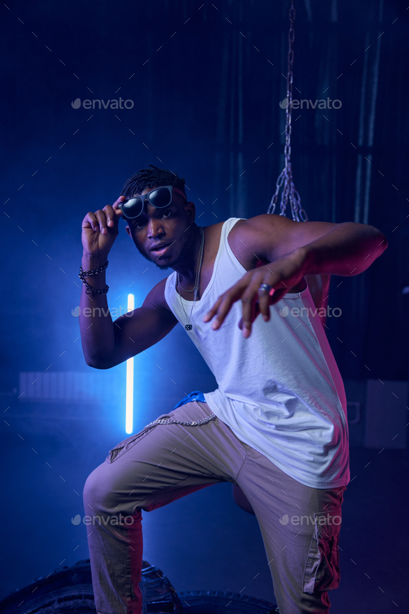Fashion muscular rapper standing in neon lights of cool nightclub Stock ...