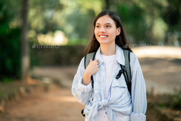 Smiling student walking with backpack at public park Stock Photo by ...
