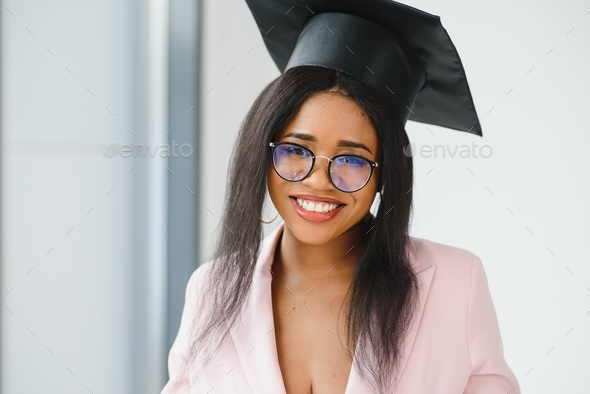 happy african american female student with diploma at graduation Stock Photo by sedrik2007