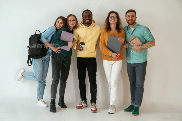 Smiling, looking forward. Group of young people are standing against ...