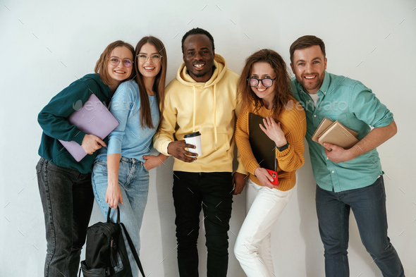 Positive friends. Group of young people are standing against white ...
