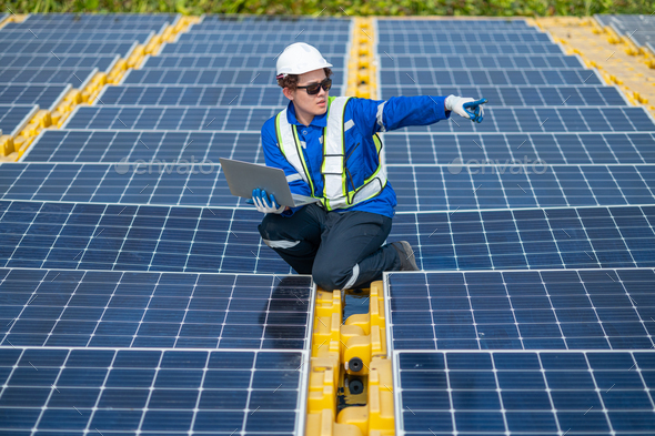 Solar Technician Monitoring Panels with Laptop Stock Photo by PICCOLINO208