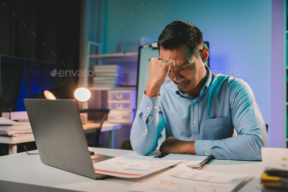 Male employee working late and stressed with failed work Young asian ...