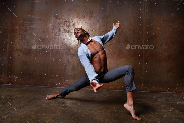 Attractive African American man showcases flexibility, leg splits and ...