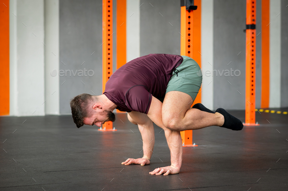 Strong man performing calisthenics frog stand exercise in gym Stock ...
