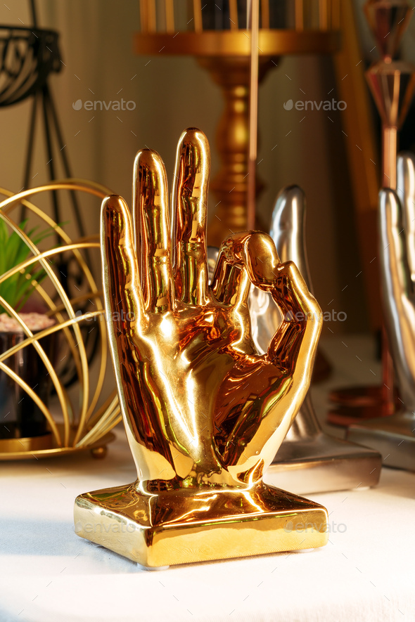 Golden Hand Sculpture on Display in a Cozy Indoor Setting at Dusk Stock ...